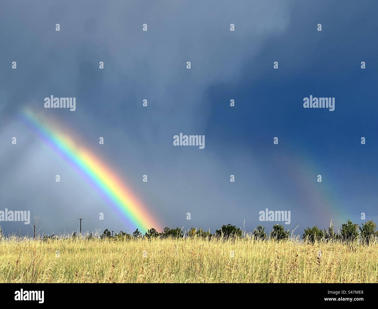 Double rainbow against dark gray sky Stock Photo - Alamy