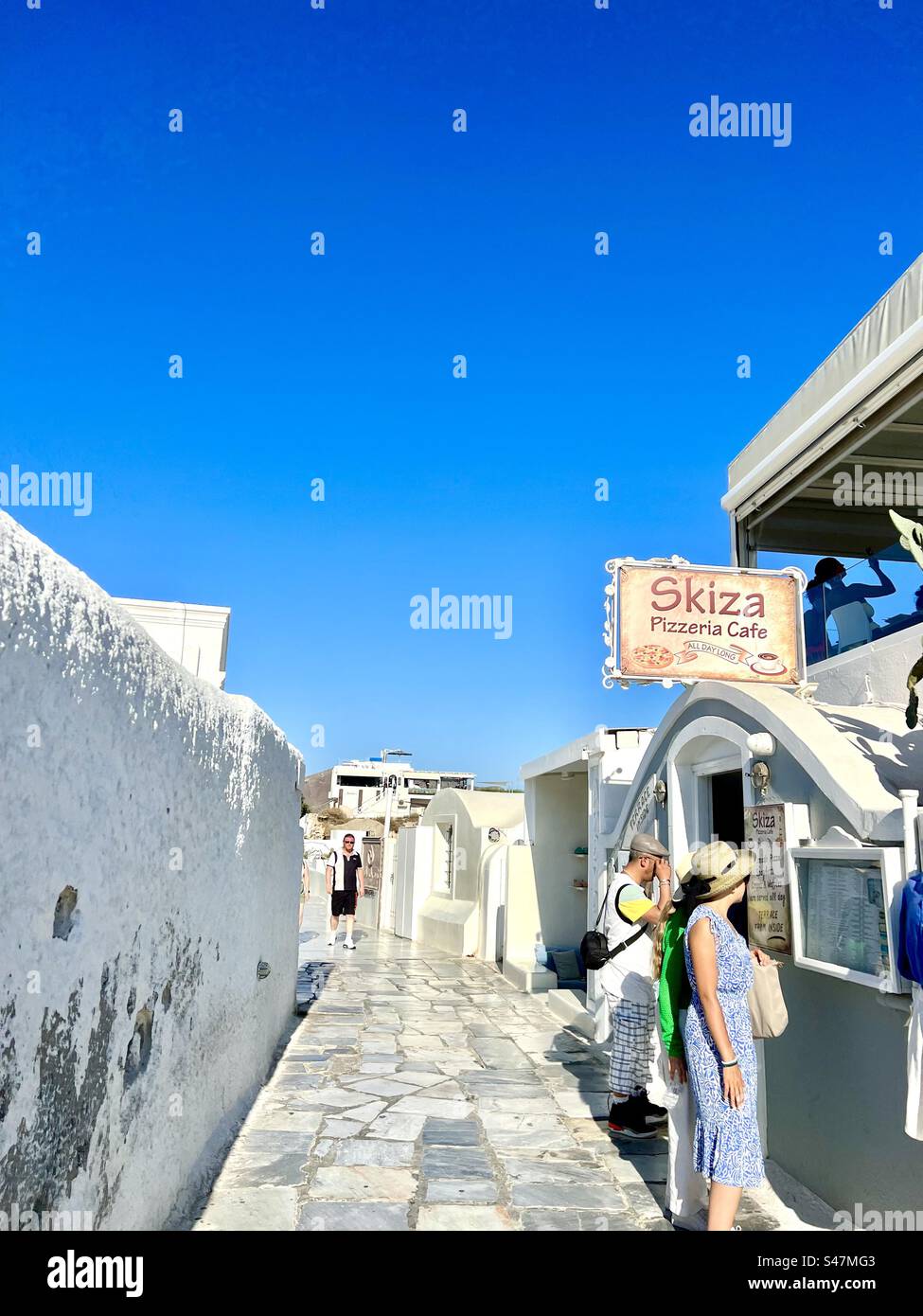 Tourists on an unusually uncrowded street in Oia, Santorini in August ...