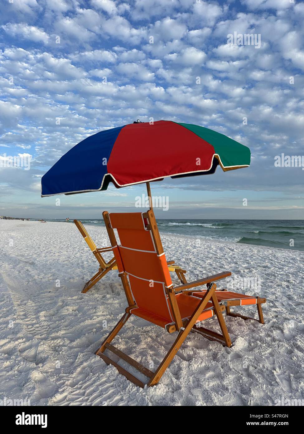 Colorful beach chairs and umbrella with soft evening clouds on Florida ...