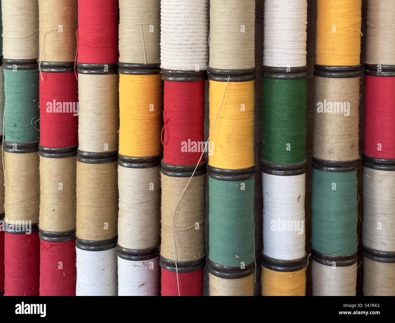 Bobbins of coloured string, forming the front of the reception counter ...