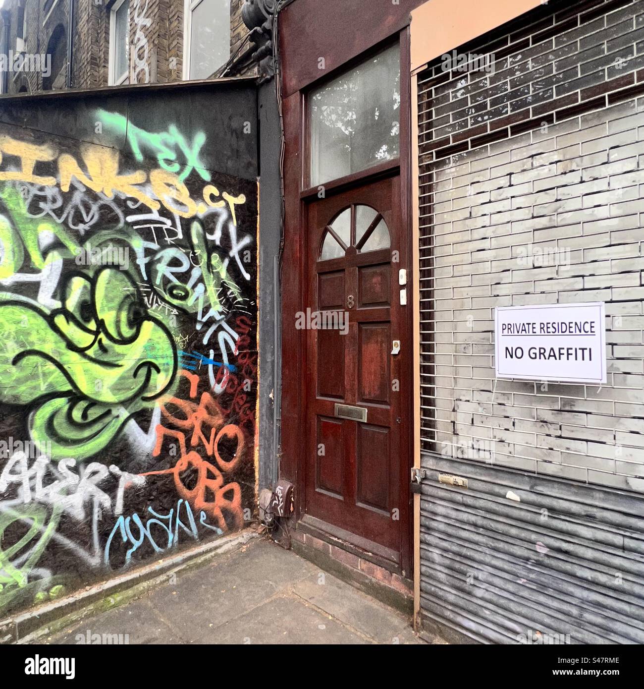 Graffiti near London House with warning sign on residential unit Stock ...