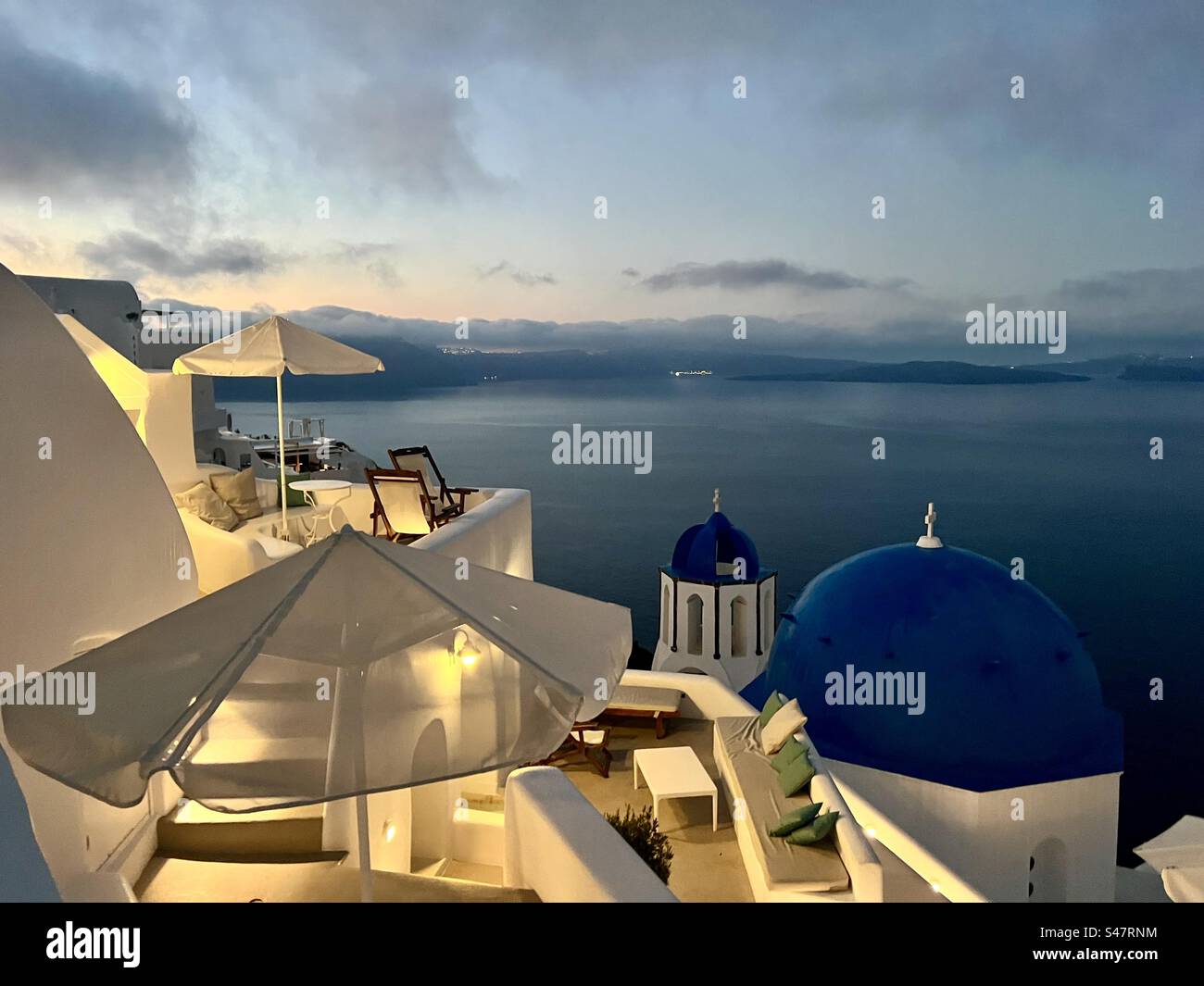 Daybreak on the cliffs of the caldera in Oia, Santorini as the early am ...