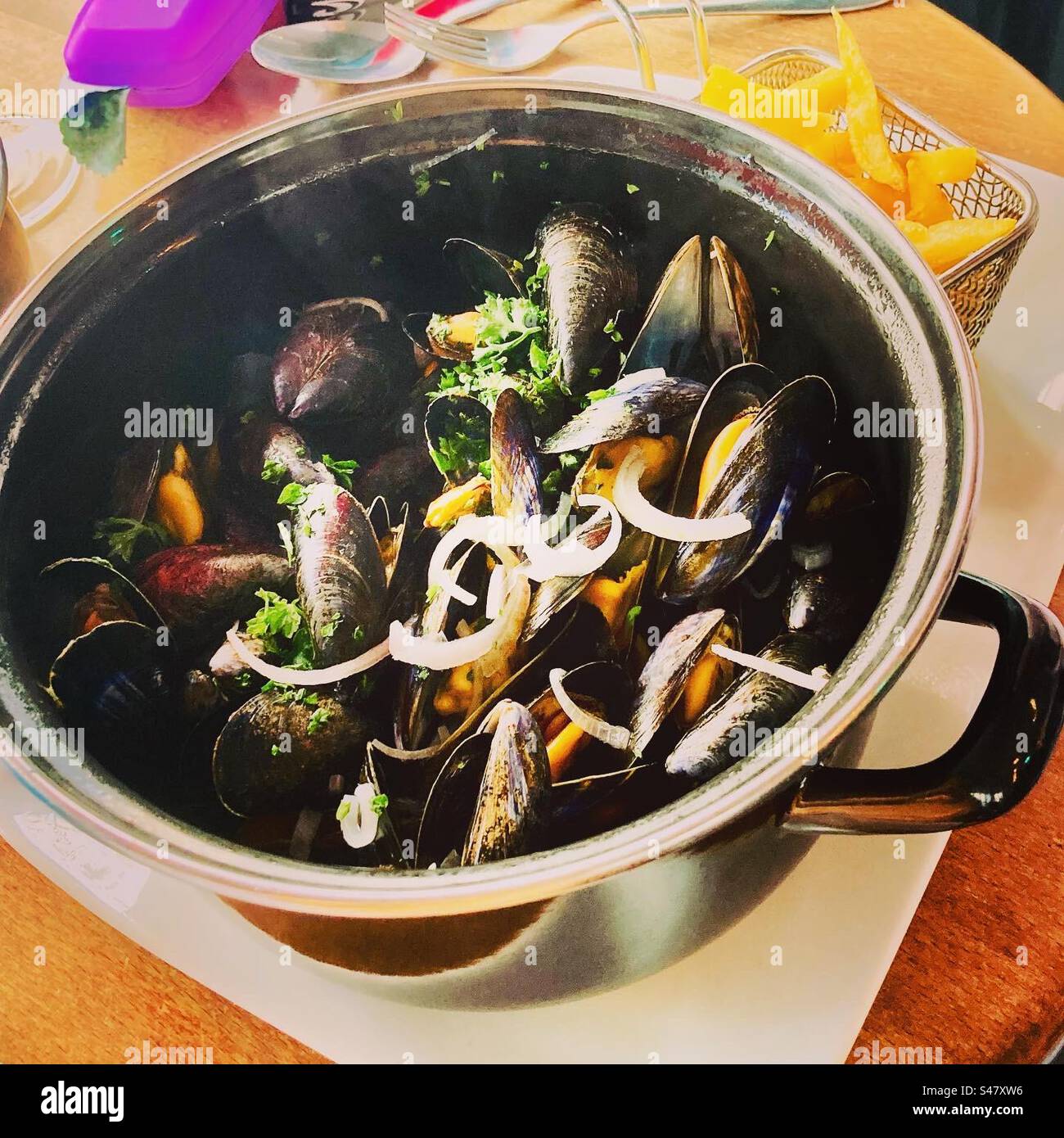 A bowl of mussels and chips in Paris France Stock Photo - Alamy