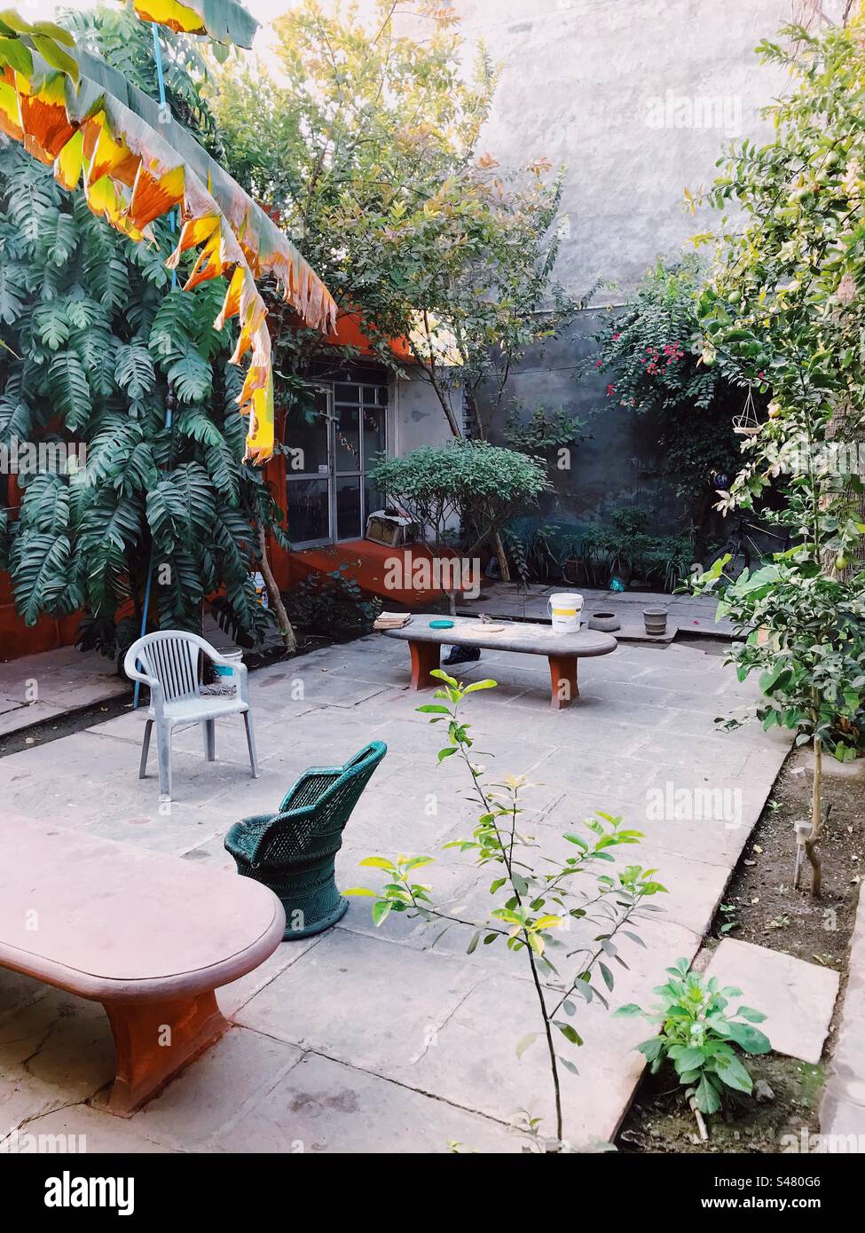 A courtyard of a house with garden chairs and greenery Stock Photo - Alamy