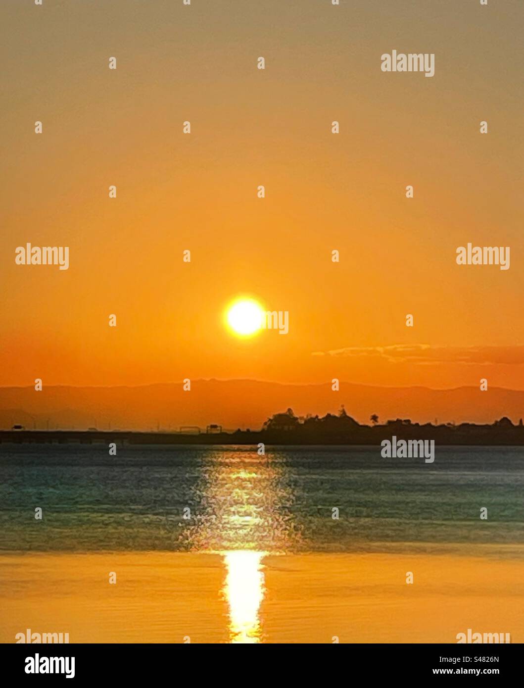 Golden sunset reflected on the water Stock Photo - Alamy