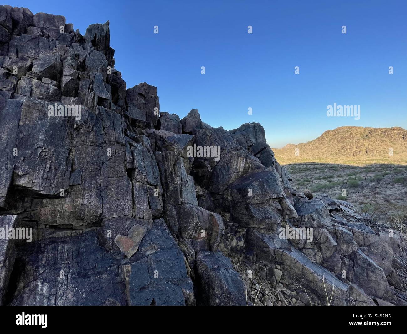 Morning Mountain shadows, brightly lit orange colored mountain peaks ...