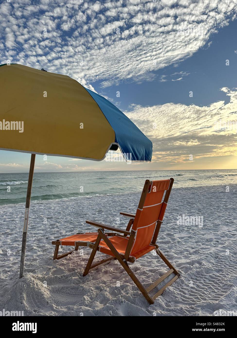 Colorful beach chair and umbrella with sunset sky background over the ...