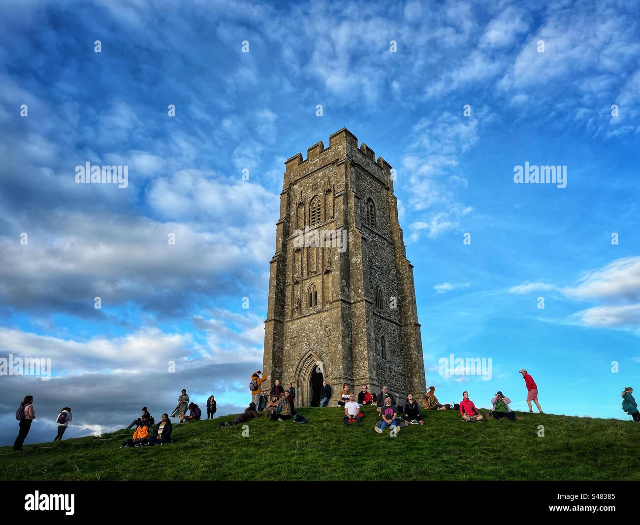 People gather to watch the sun go down from Glastonbury Tor in Somerset ...