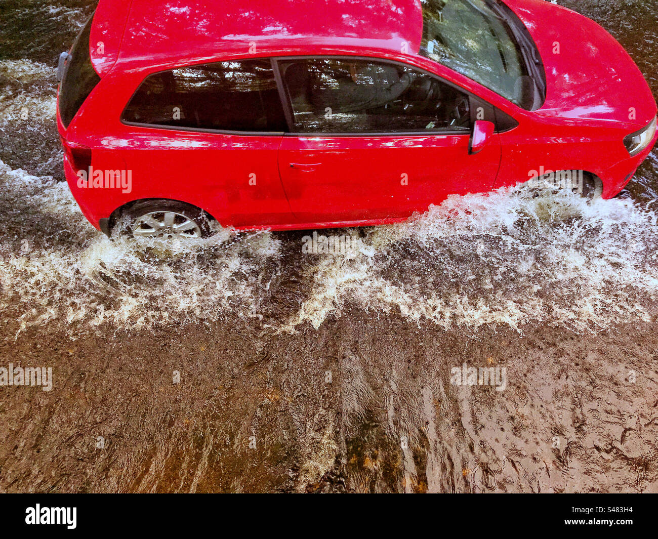 Car crossing fast flowing river through ford after heavy rains Stock ...