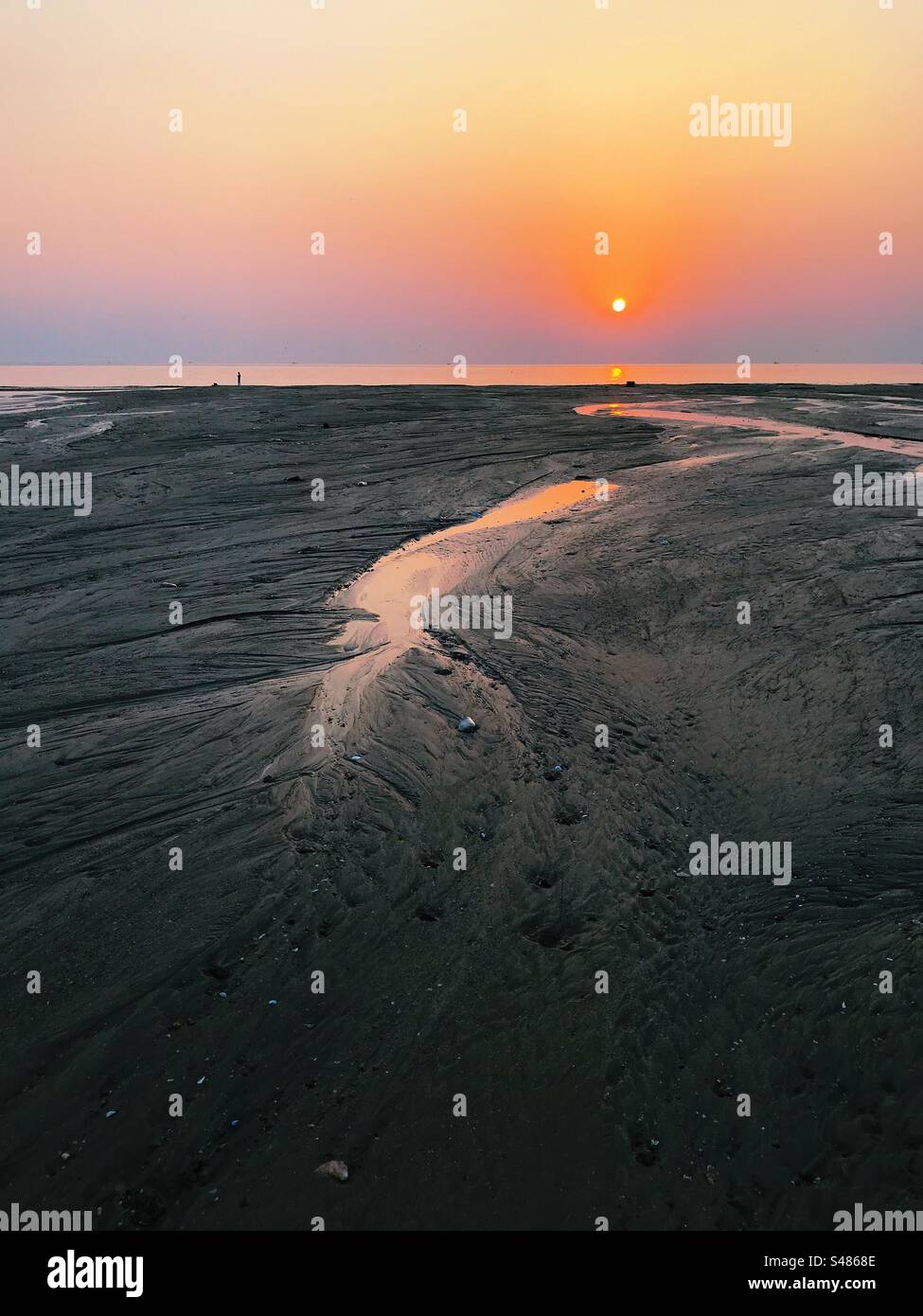 Sunset with textures of the beach in the foreground Stock Photo - Alamy