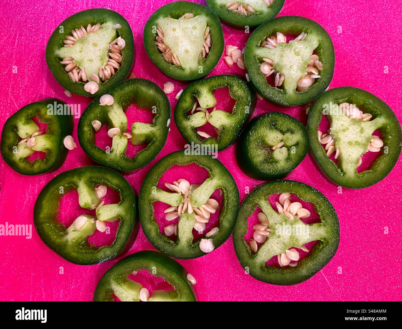 Slices of jalapeños on a red cutting board Stock Photo - Alamy