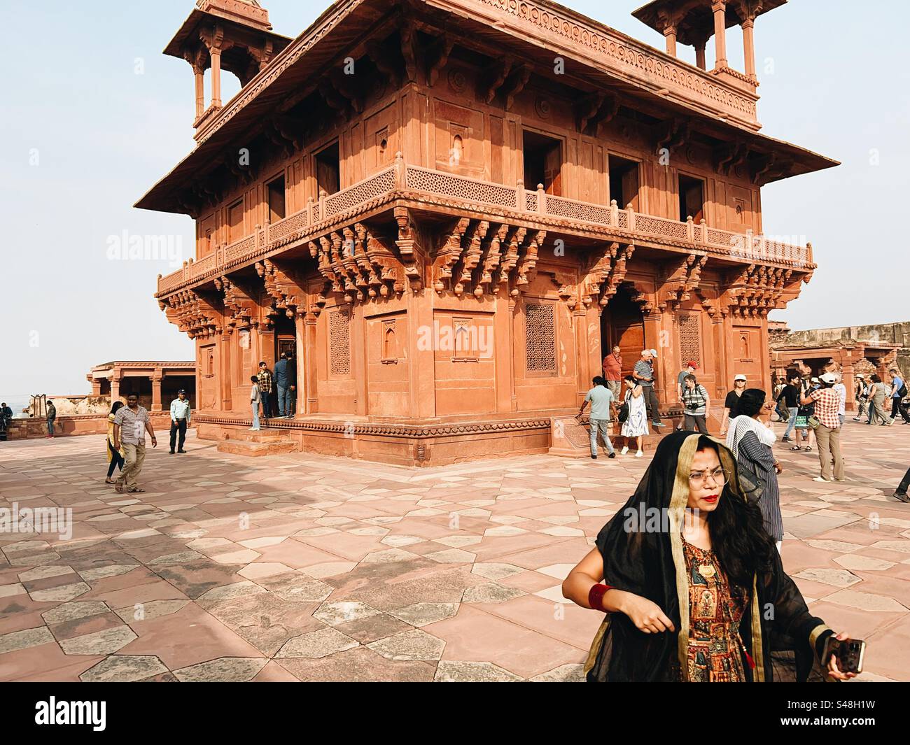 A women dressed in traditional Indian clothes standing in front of ...