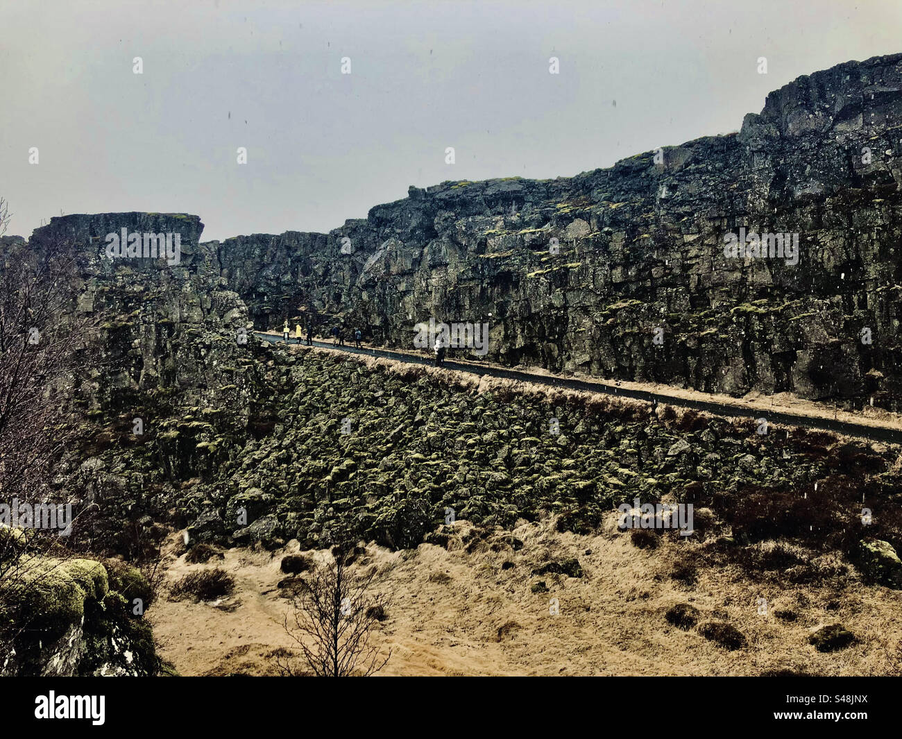 A tall cliff and path near the plate boundary in Iceland. There are ...