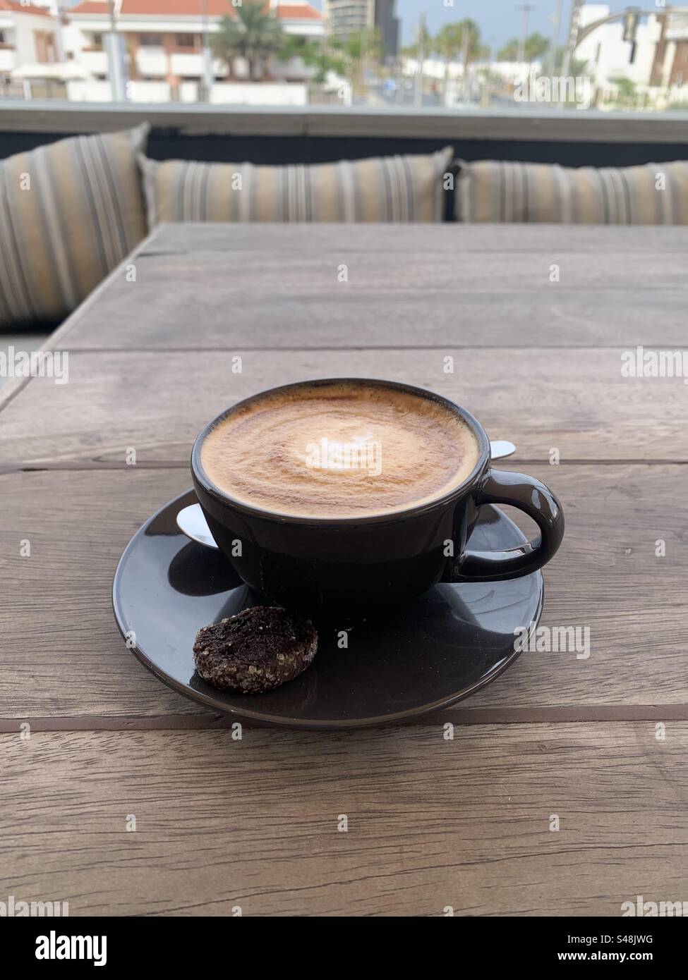 A freshly prepared cup of cortado coffee served on an outdoor terrace ...