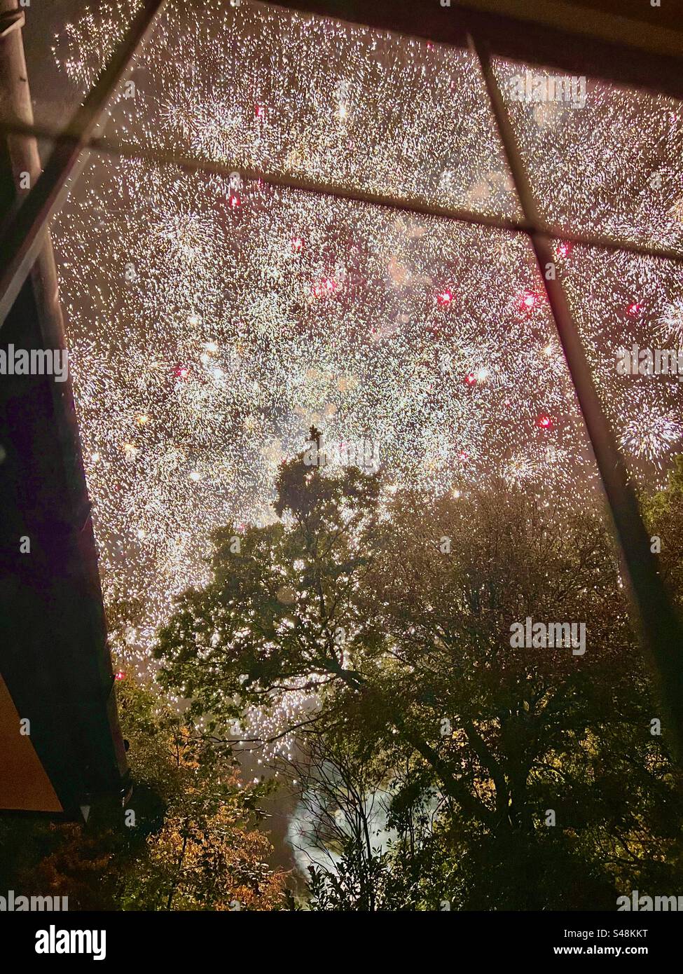 Fireworks viewed through bedroom window Stock Photo - Alamy