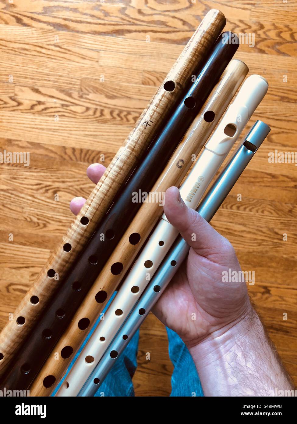 A hand holding five flutes Stock Photo - Alamy