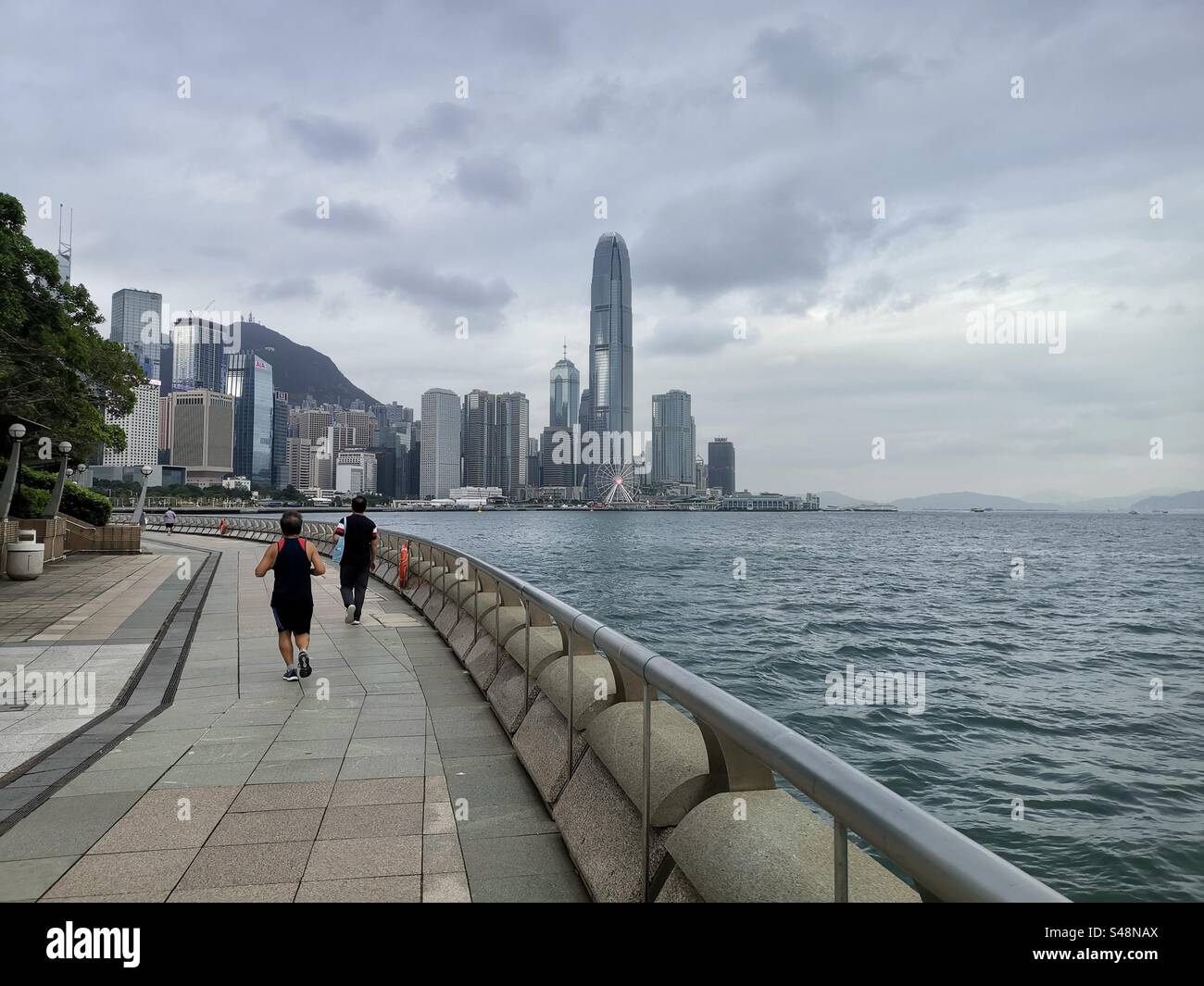 Jogging on the waterfront promenade in Hong Kong Stock Photo - Alamy