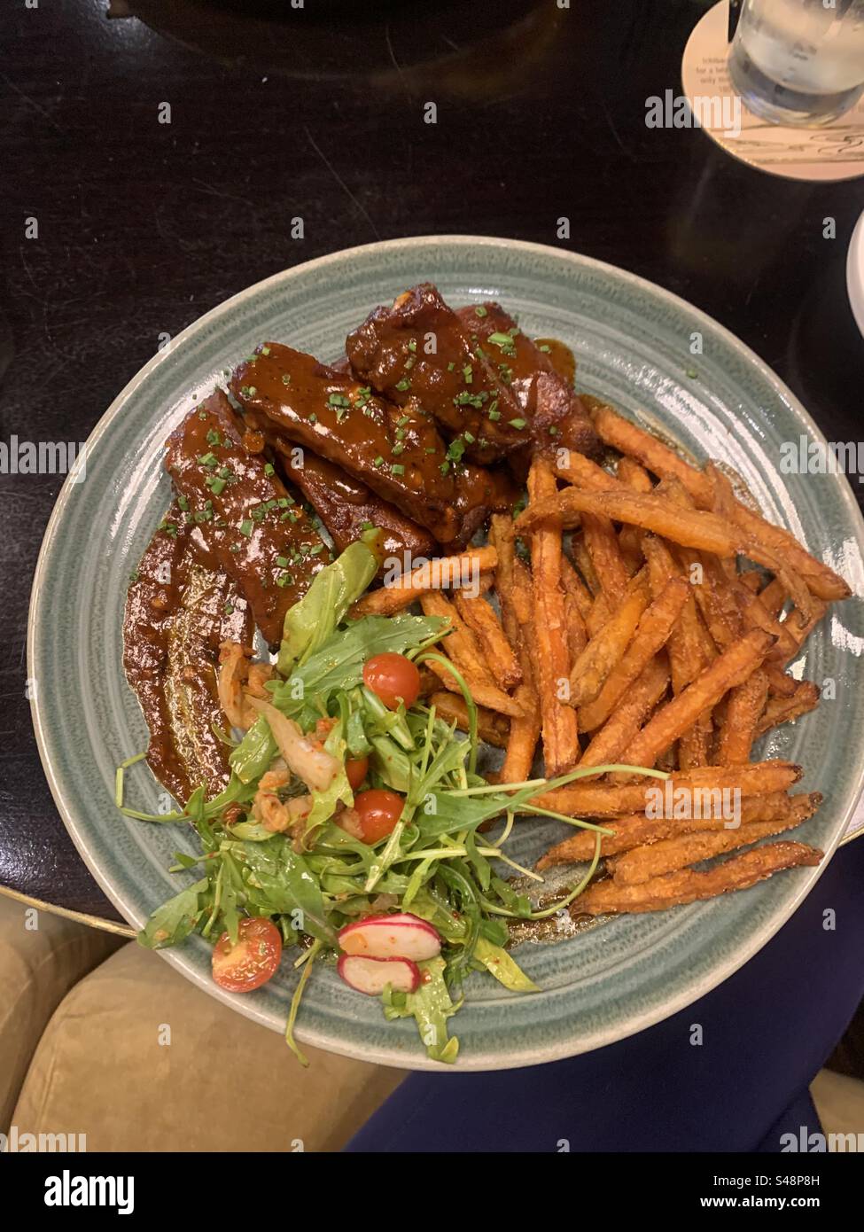 Baby back pork ribs with sweet potato fries and kimchi salad served in ...