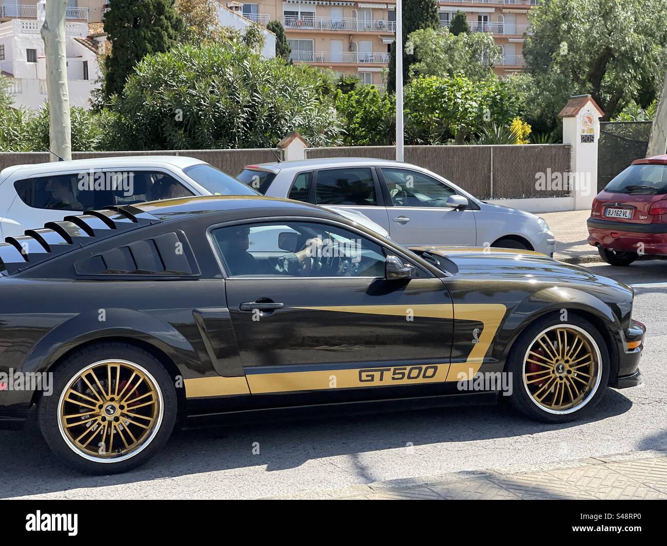Shot of a black and gold Ford Mustang GT500 driving by on the Costa ...
