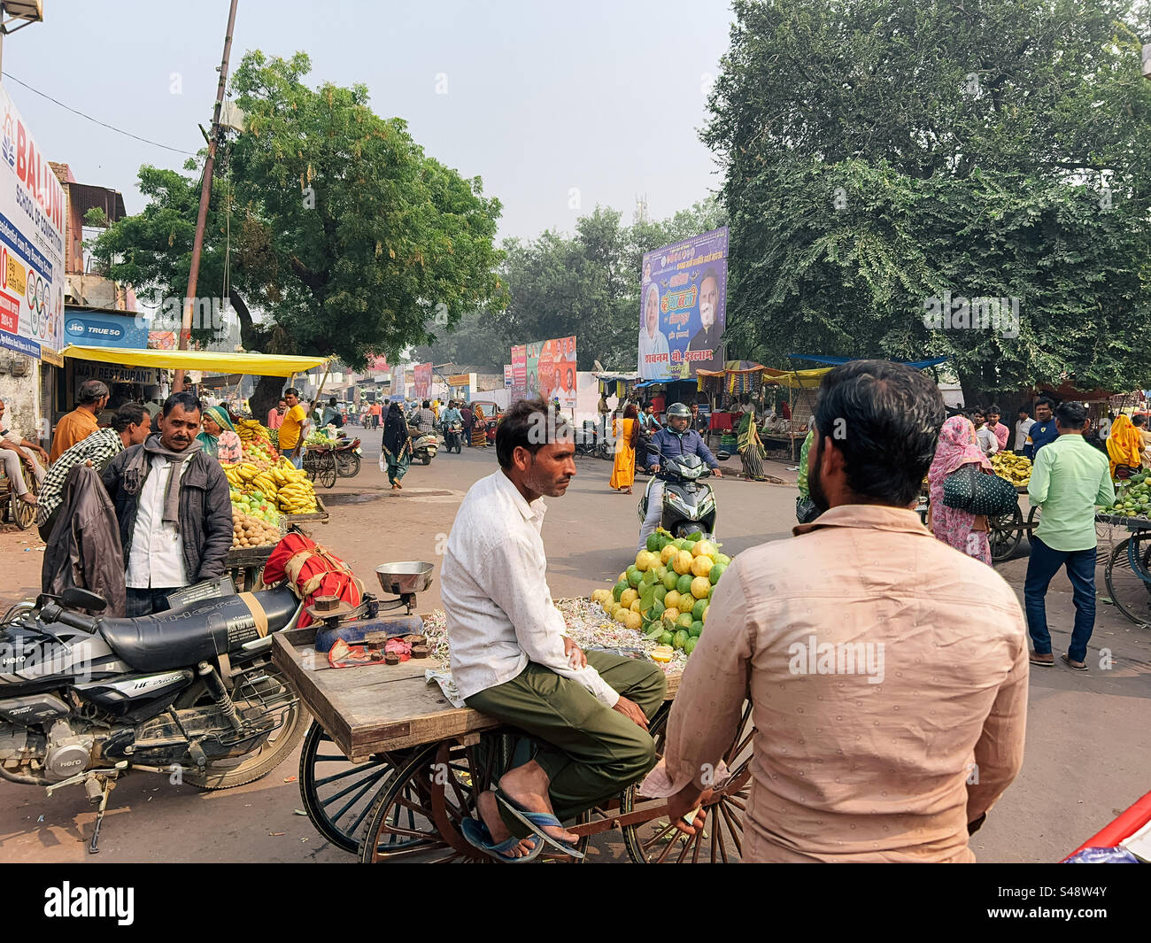 An Indian market scene full of shops and street vendors selling fruits ...