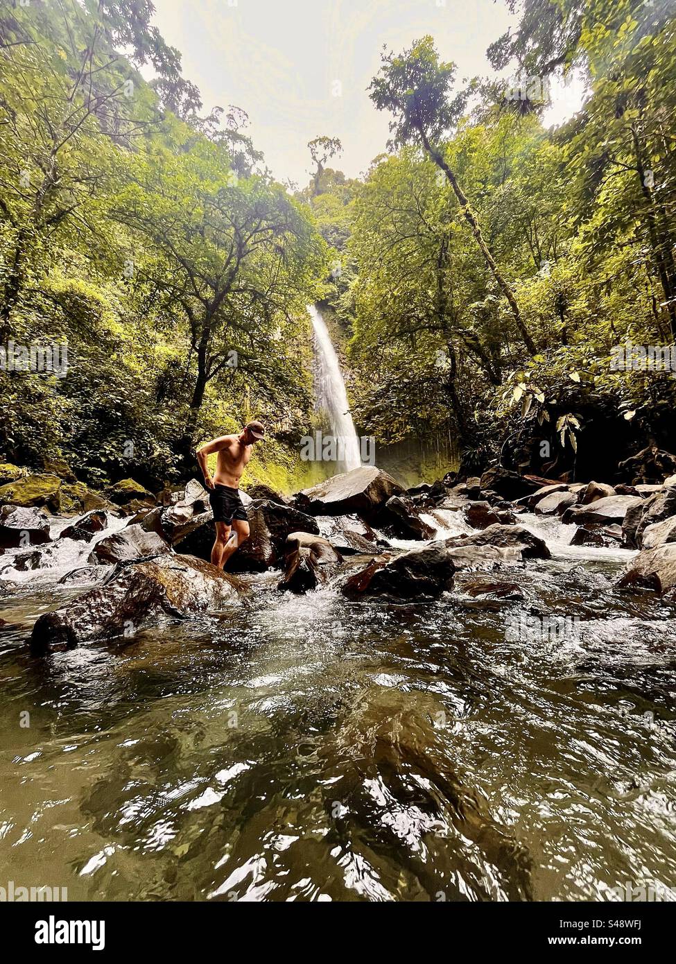 A young man prepares to swim below the La Fortuna Falls in Alajuela ...