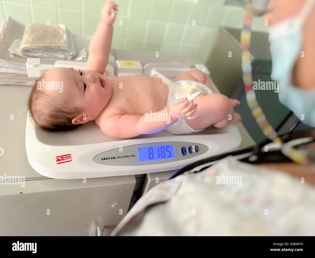 Baby being weighted at a pediatric appointment Stock Photo - Alamy