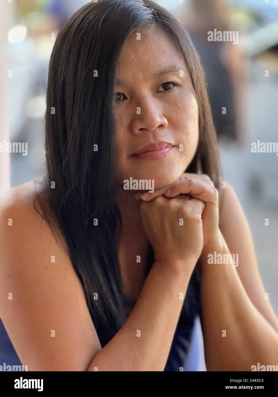 Beautiful and young Filipino woman gazing in the distance, wishful ...