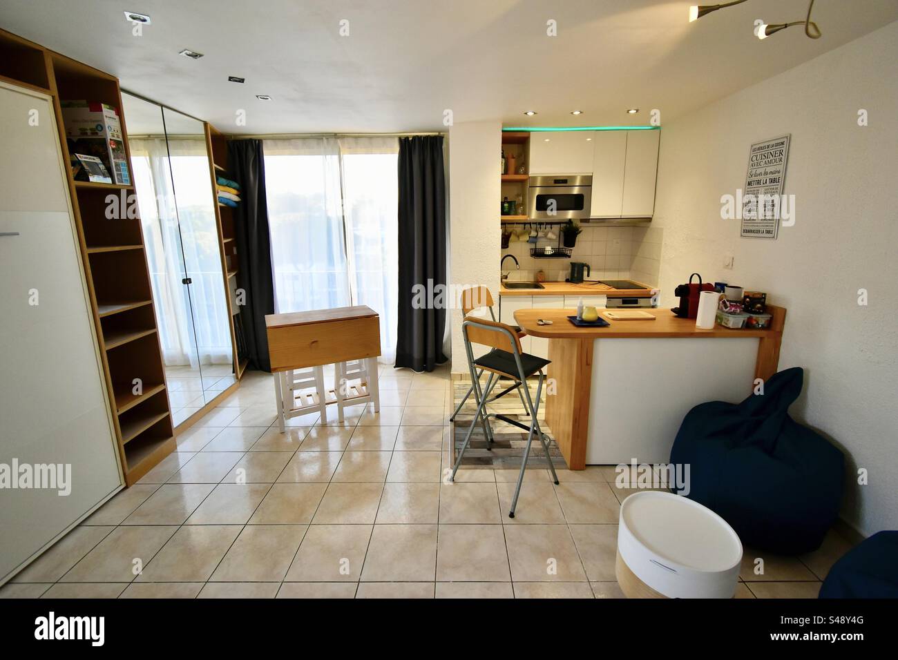 Wide Interior shot of a studio apartment with table and chairs ...