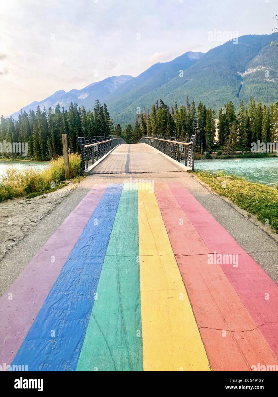 The rainbow flag painted at the entrance of the Banff Pedestrian Bridge ...