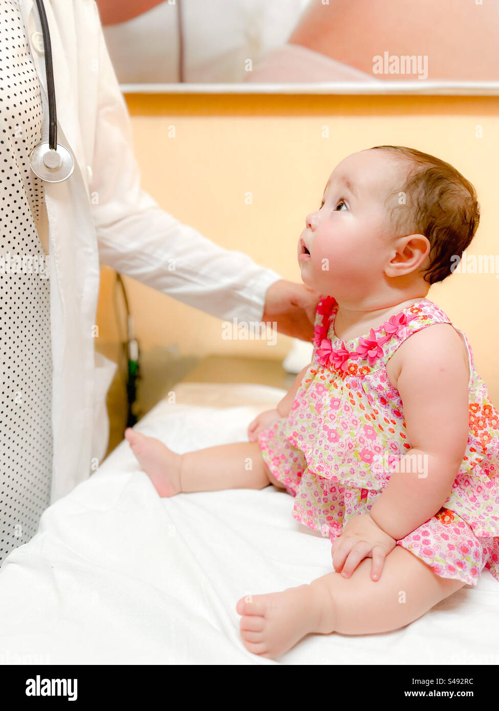 Baby looking at female doctor at a pediatric check-up appointment Stock ...