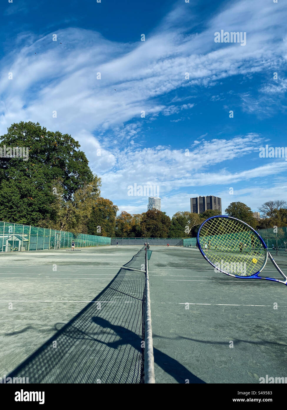 Shadow of a person holding a blue tennis racket on a sunny day with ...