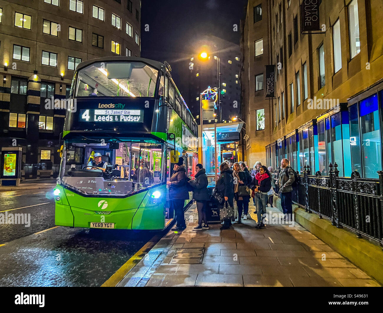 Queuing and getting on a bus in Leeds city centre at night Stock Photo ...