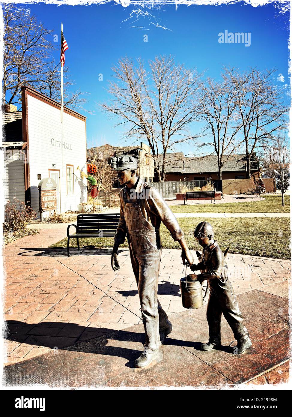 Statue of coal miner, holding a bucket with his son behind him. Located ...