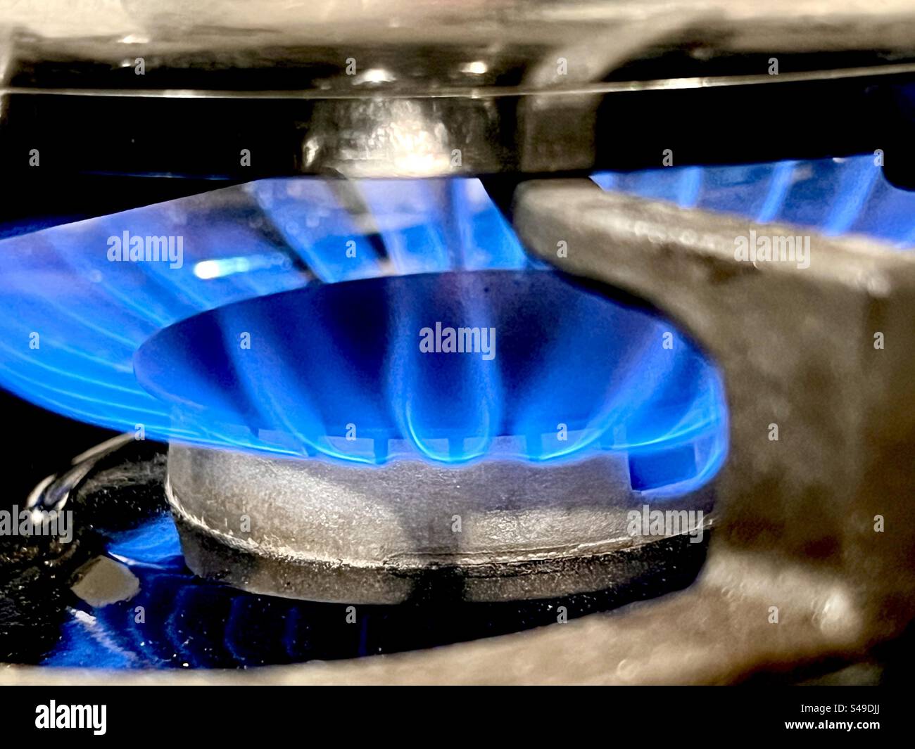 Gas pilot light on stove top with blue flame Stock Photo - Alamy