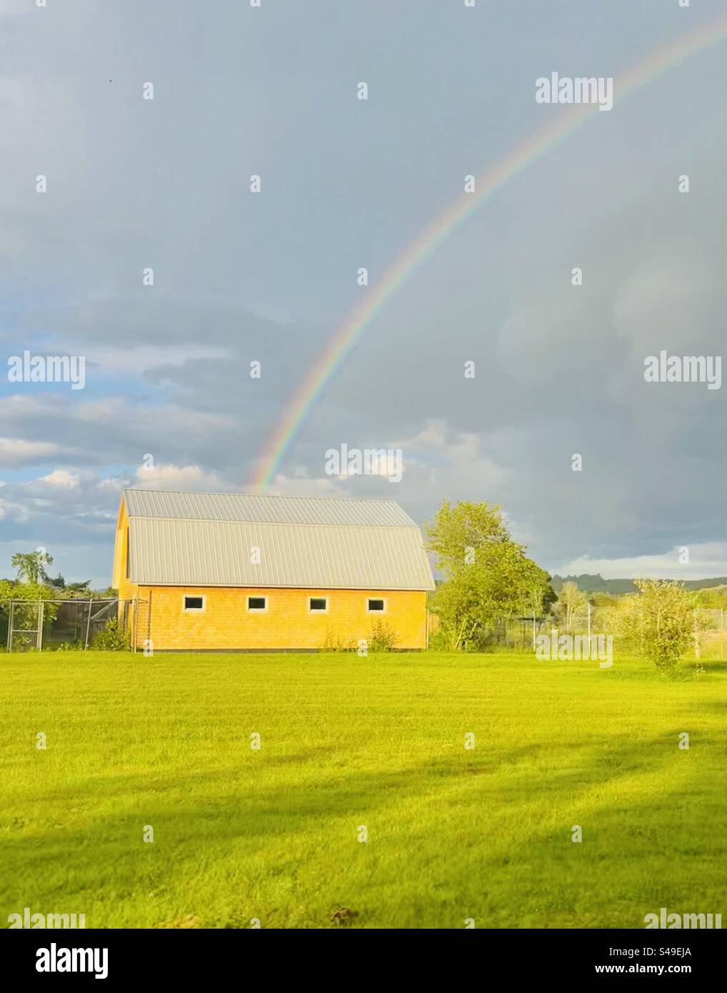 Rainbow and a yellow barn in Acadia Maine Stock Photo - Alamy