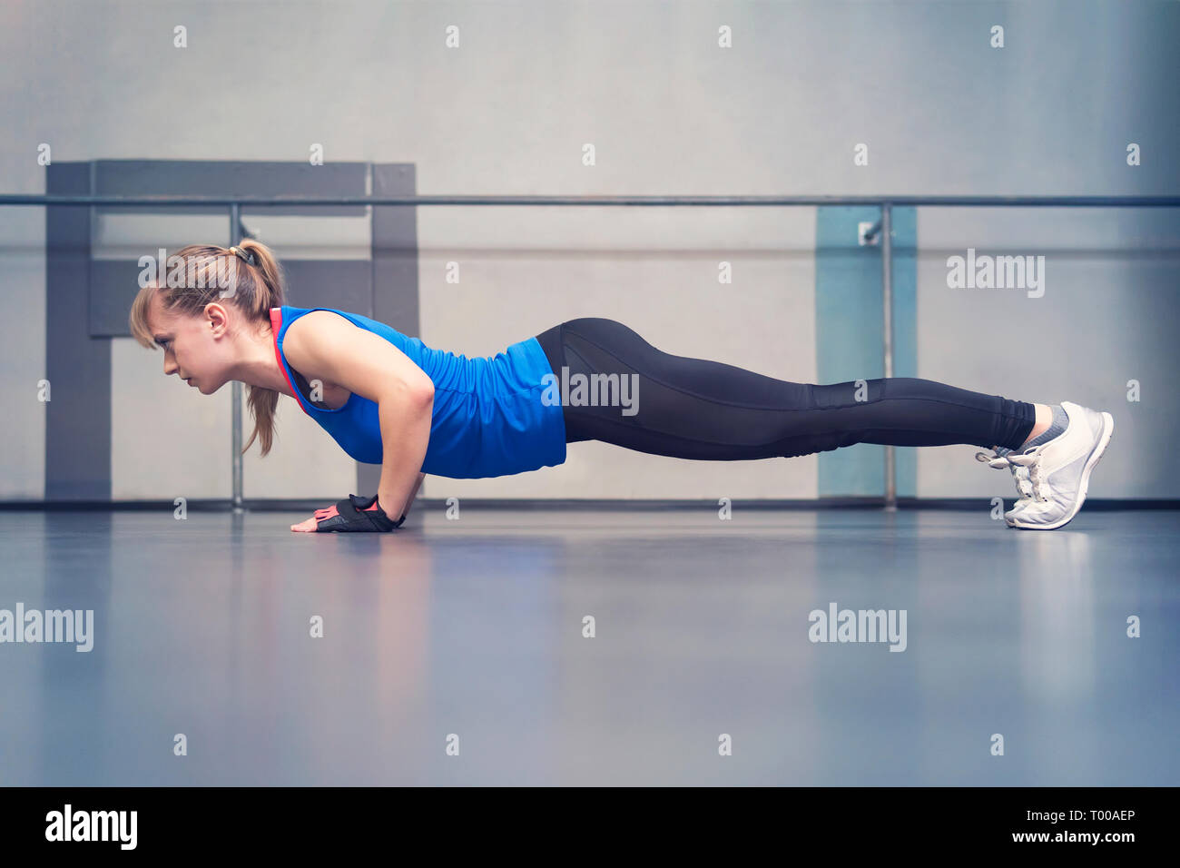 A girl with a beautiful sports figure in the Fitness room on the floor ...