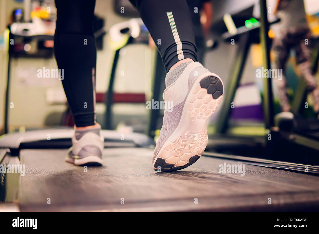 Close up shoes woman's muscular legs feet running on treadmill workout ...