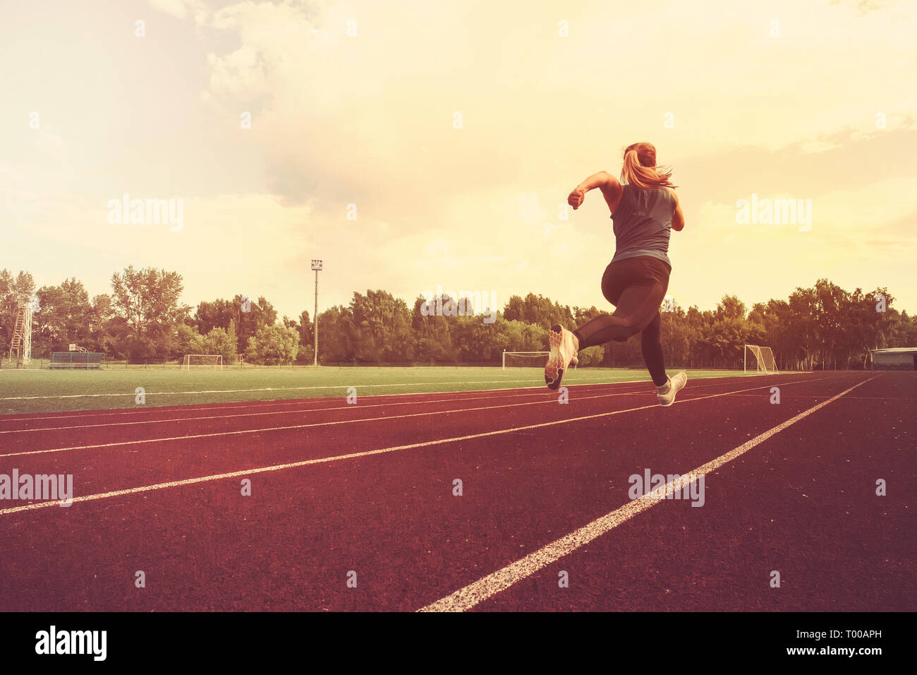 athletic girl is running athletic girl is running at stadium. A young ...