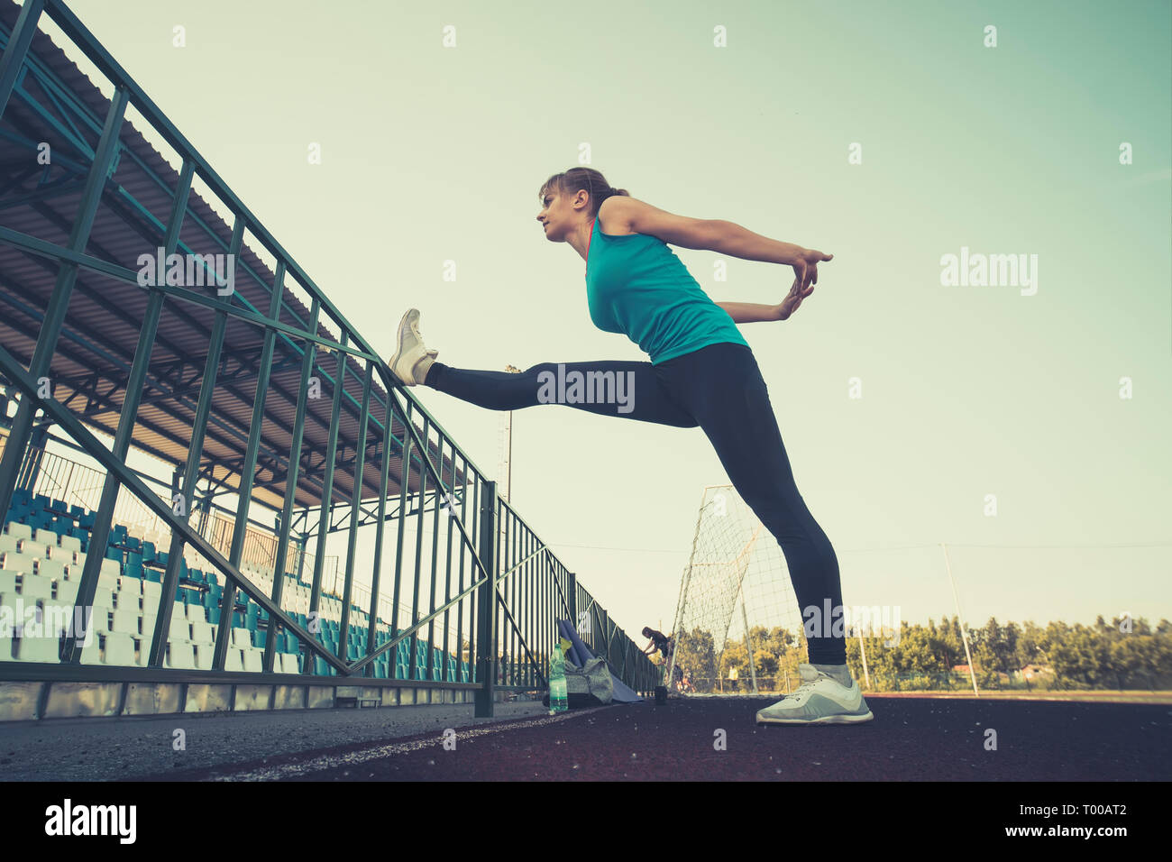 Young woman stretching hand and legs before her run.Woman runner ...