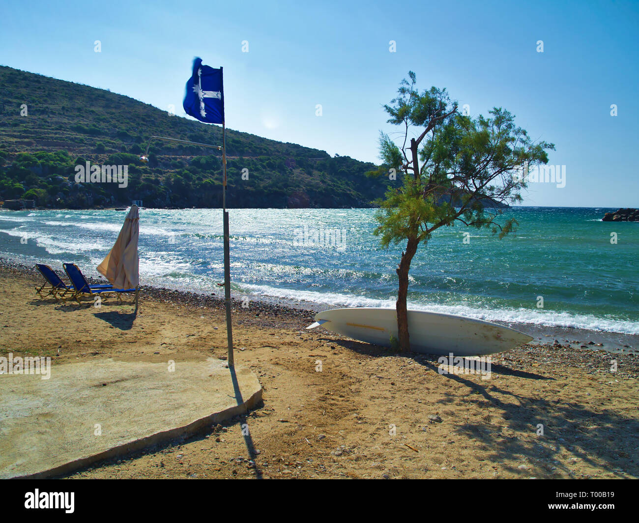Beautiful beach blue flag, tree and surf board in Chios island Greece ...
