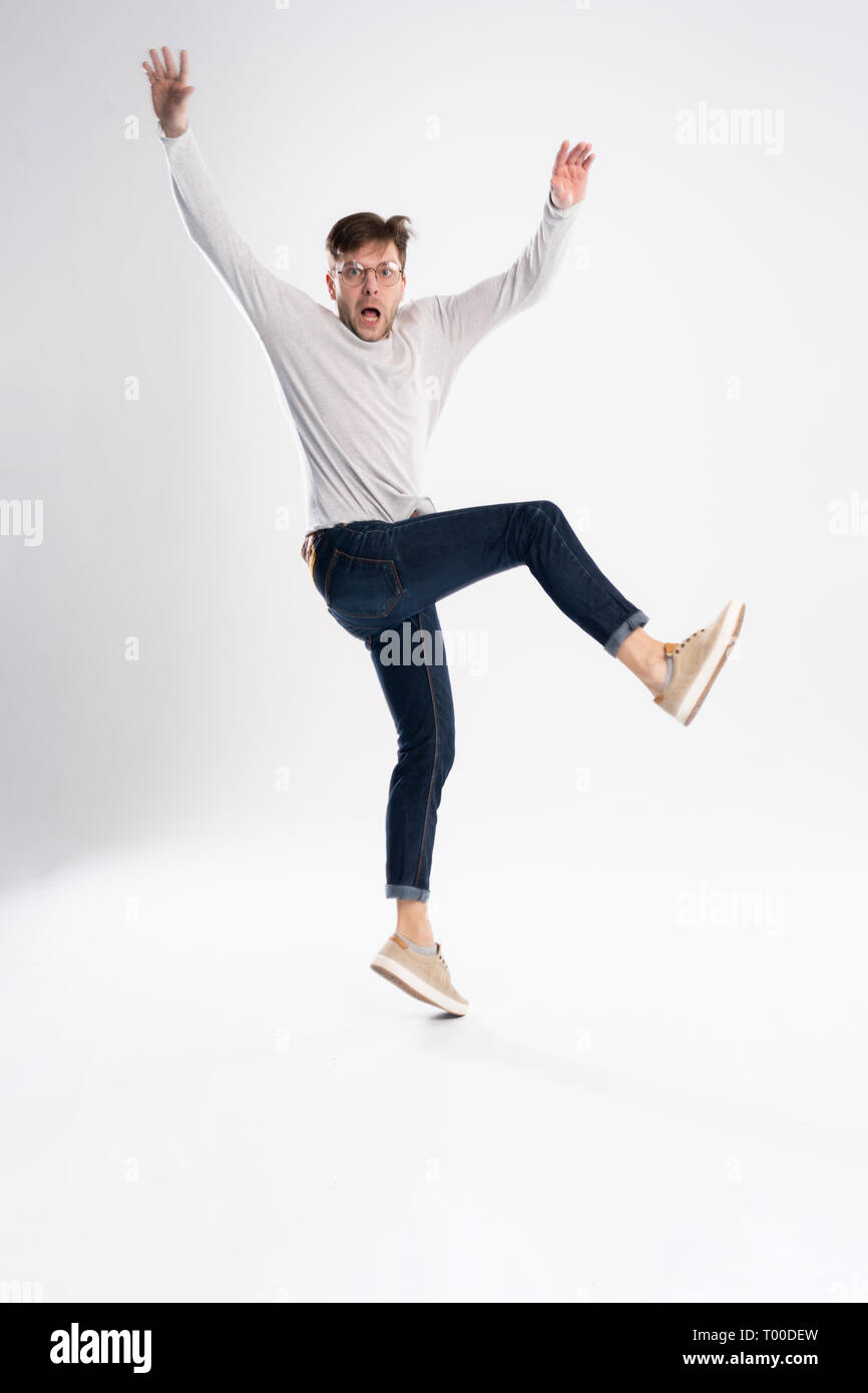 Full-length photo of funny man 30s in casual t-shirt and jeans jumping ...