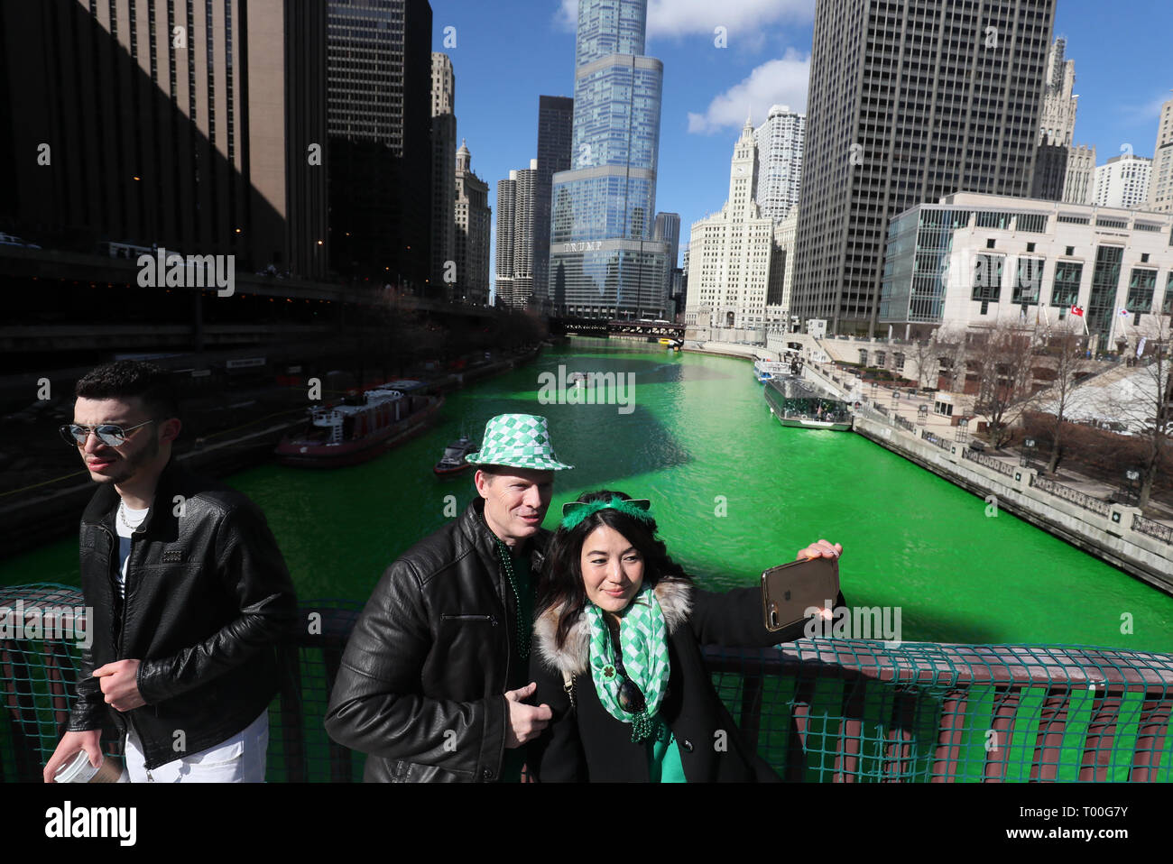 A couple take a selfie as the Chicago River in Chicago, USA, is turned ...