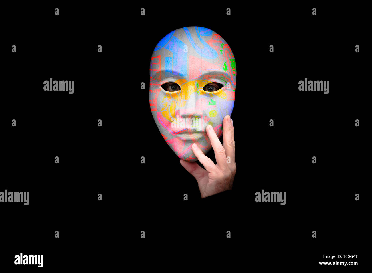 Person with hand to face in a colourful mask against a black background ...