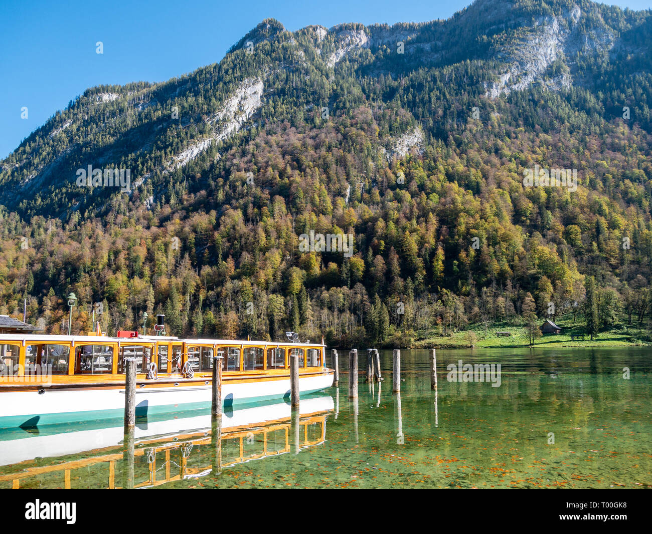 Classic image of the Koenigssee with a water reflection of a tourist ...