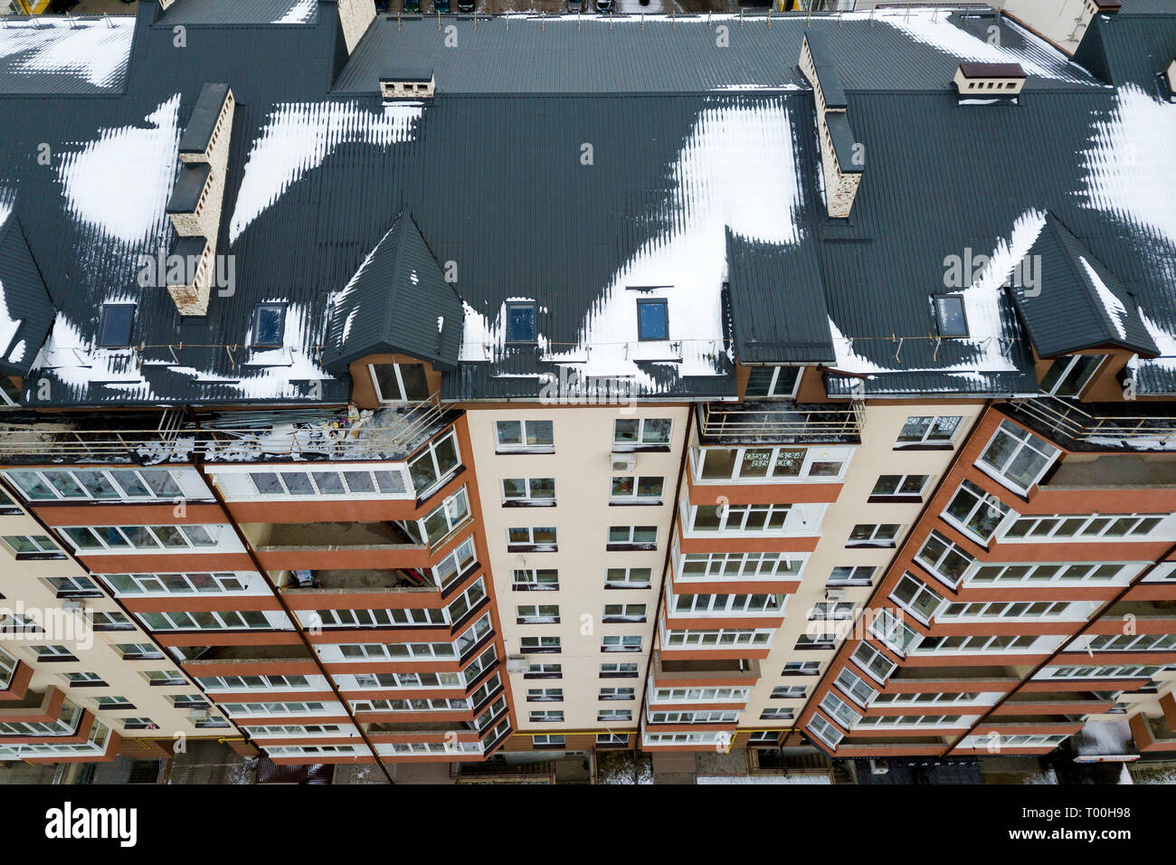 Aerial winter top view of tall apartment building, brick chimneys ...