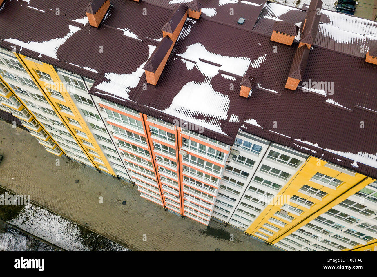 Aerial winter top view of tall apartment building, brick chimneys ...