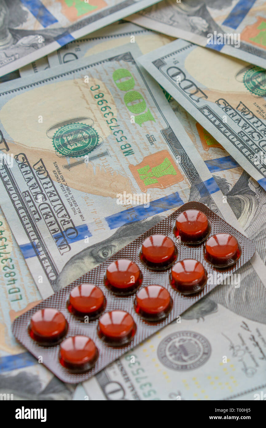 Pills on 100 dollar money. Medicine expenses. High costs of expensive ...