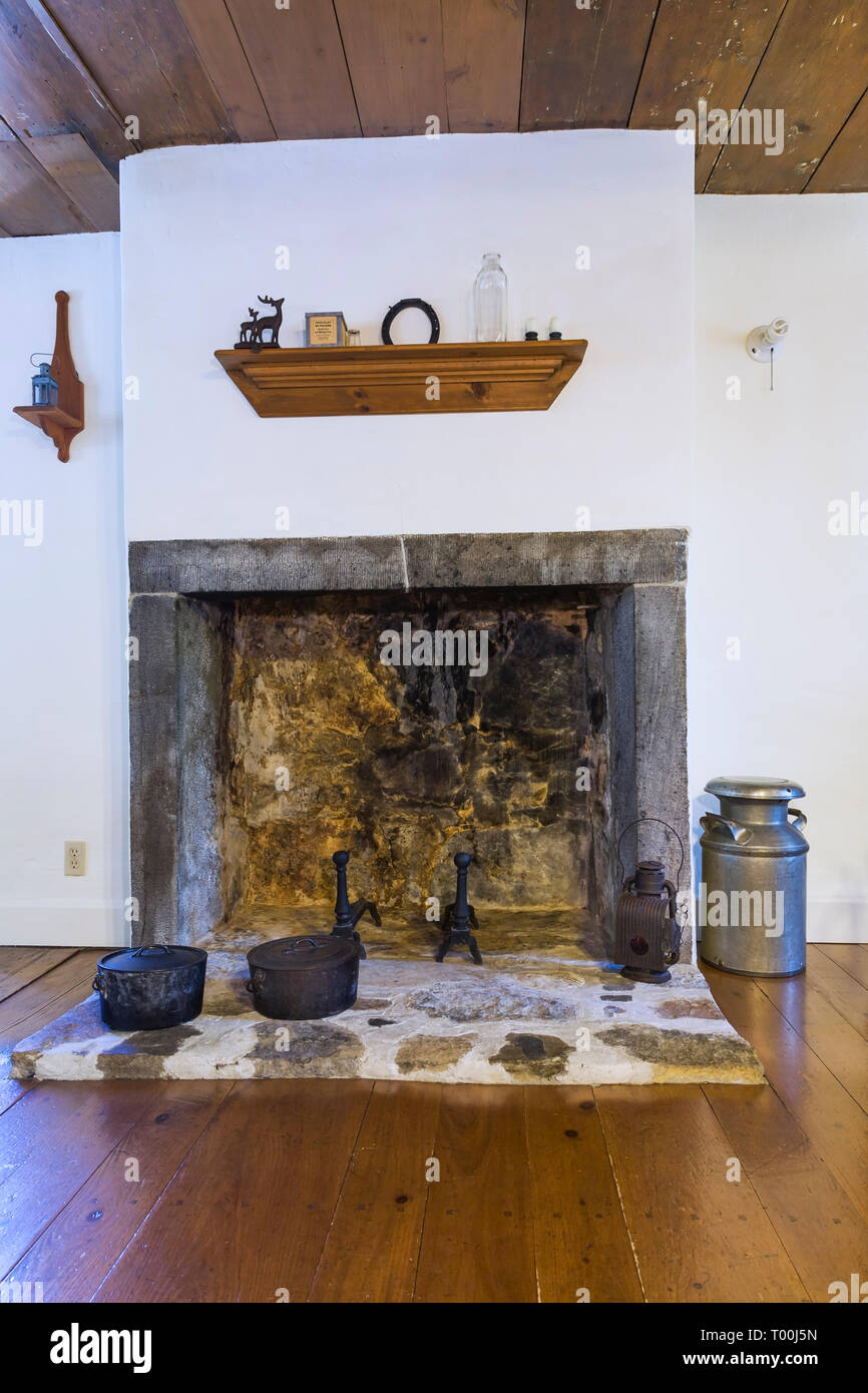 Fieldstone fireplace with cut stone contour, roughcast finish and black ...