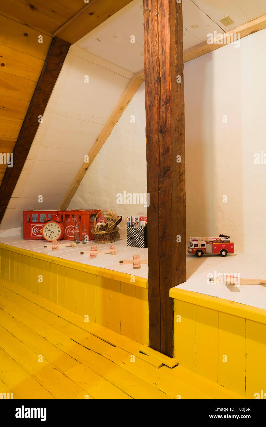 Vintage toys and empty Coca-Cola bottles on raised platform in attic ...