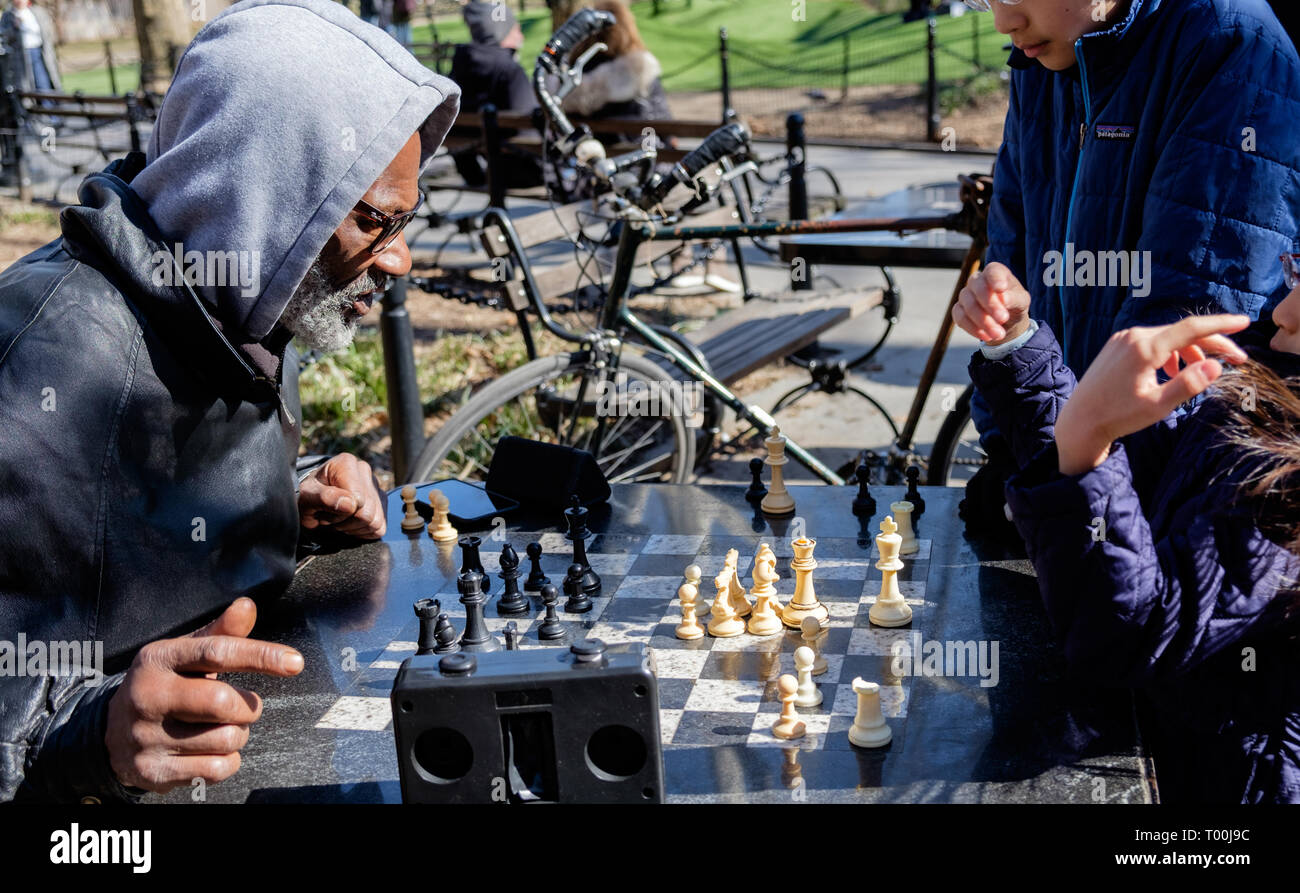 Adult chess player looks at playing board during a game while children ...